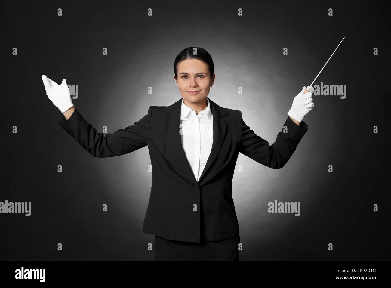 Professional conductor with baton on black background Stock Photo - Alamy