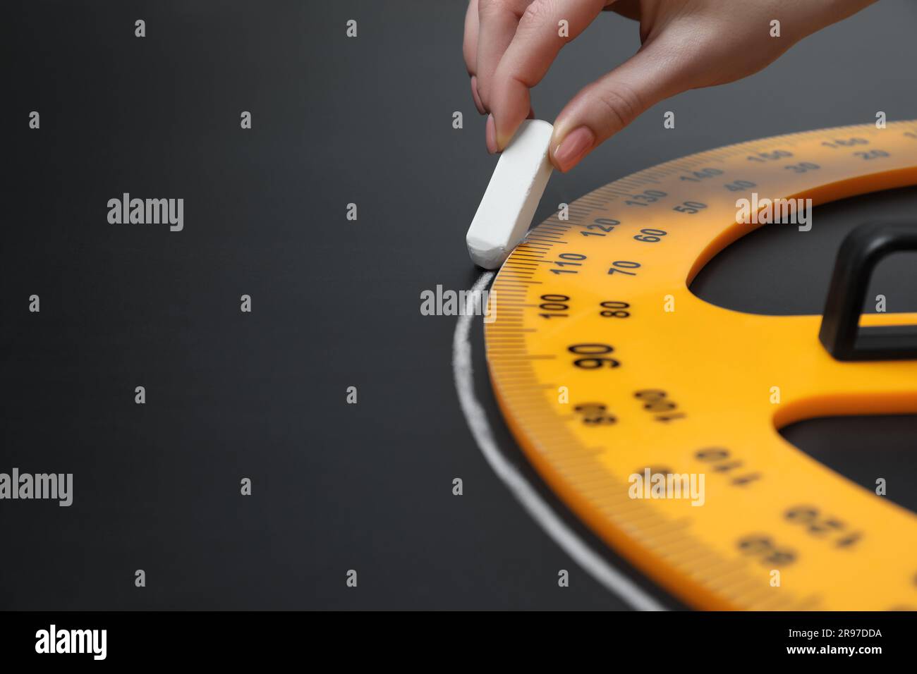 Woman drawing with chalk and protractor on blackboard, closeup. Space ...