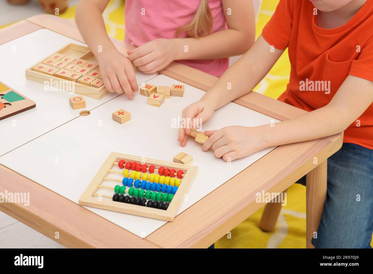 Children playing with different math game kits at desk indoors, closeup ...