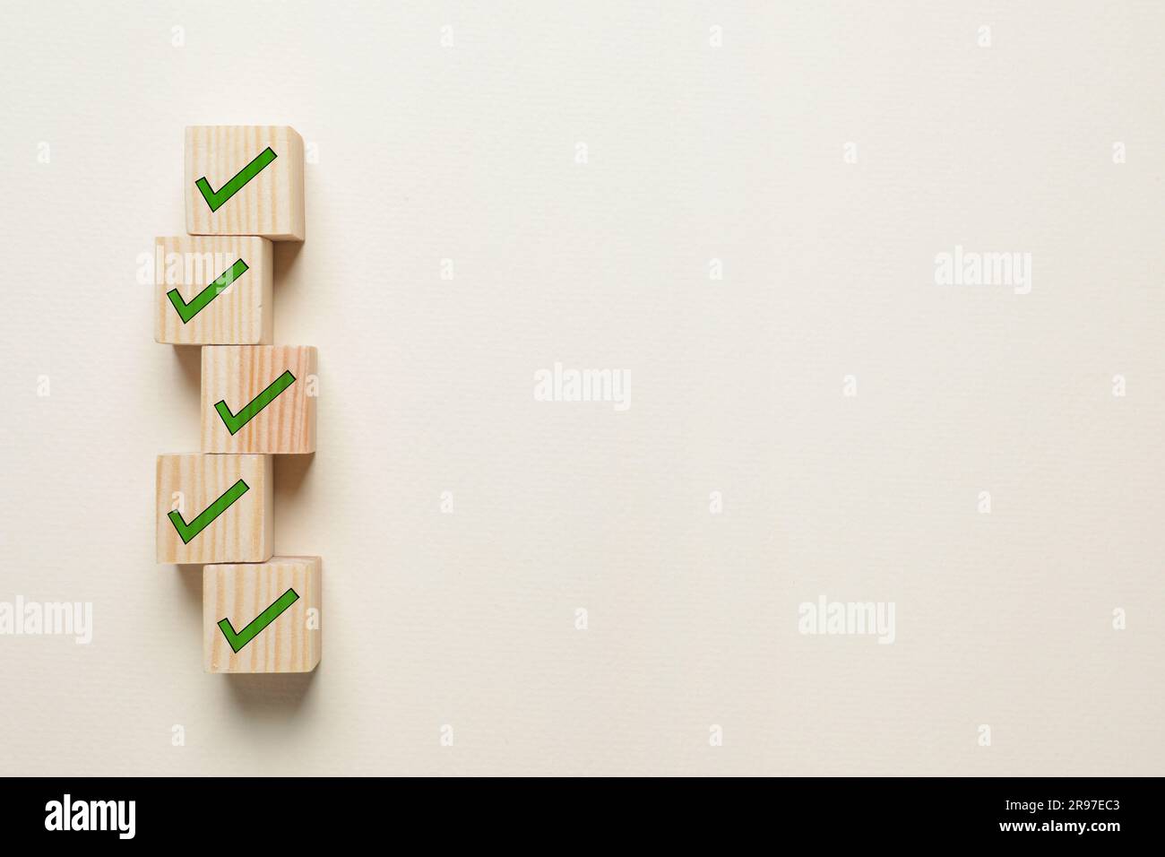 Wooden cubes with check marks on beige background, flat lay. Space for ...