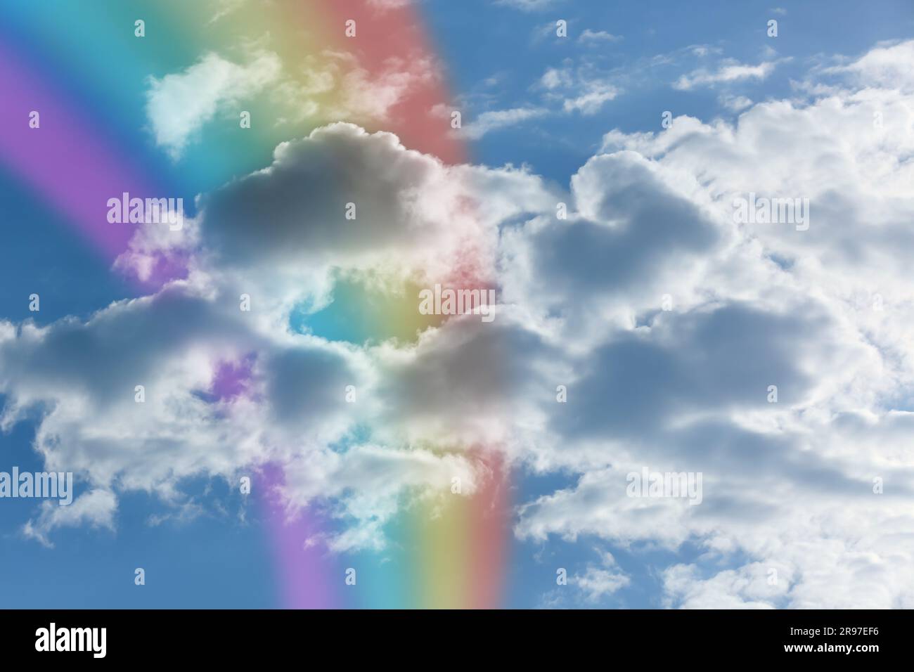 Beautiful sky with bright rainbow and fluffy clouds Stock Photo - Alamy