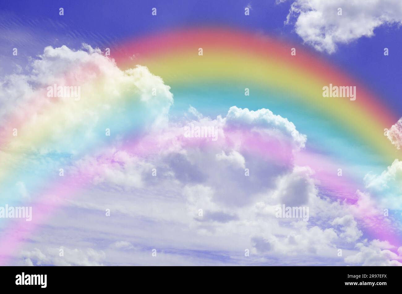 Beautiful sky with bright rainbow and fluffy clouds Stock Photo - Alamy