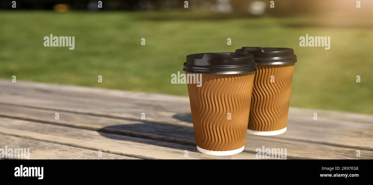Takeaway cardboard coffee cups with plastic lids on wooden bench ...