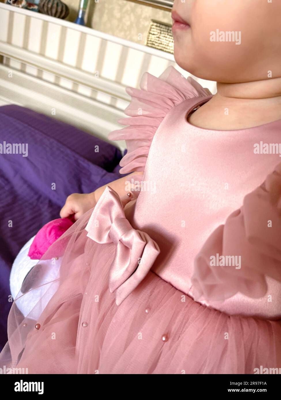 Dressed up little girl toddler in pink dress with bow, frills and ...