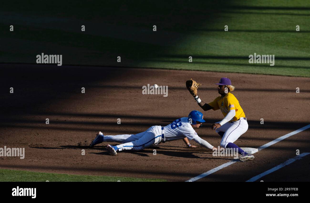 Florida's Luke Heyman, left, dives safely back into first base ahead of ...