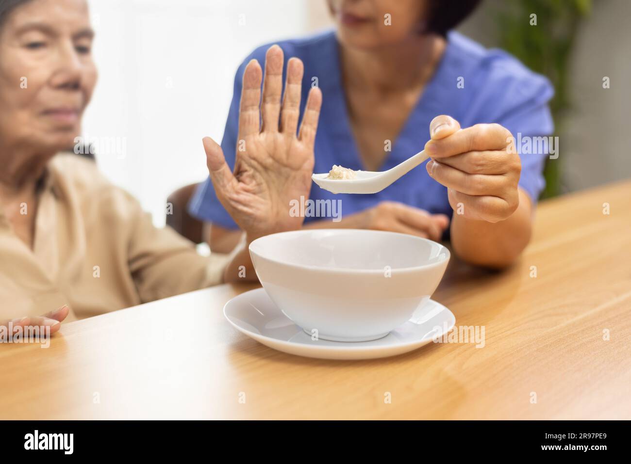 Senior asian woman bored with food Stock Photo - Alamy