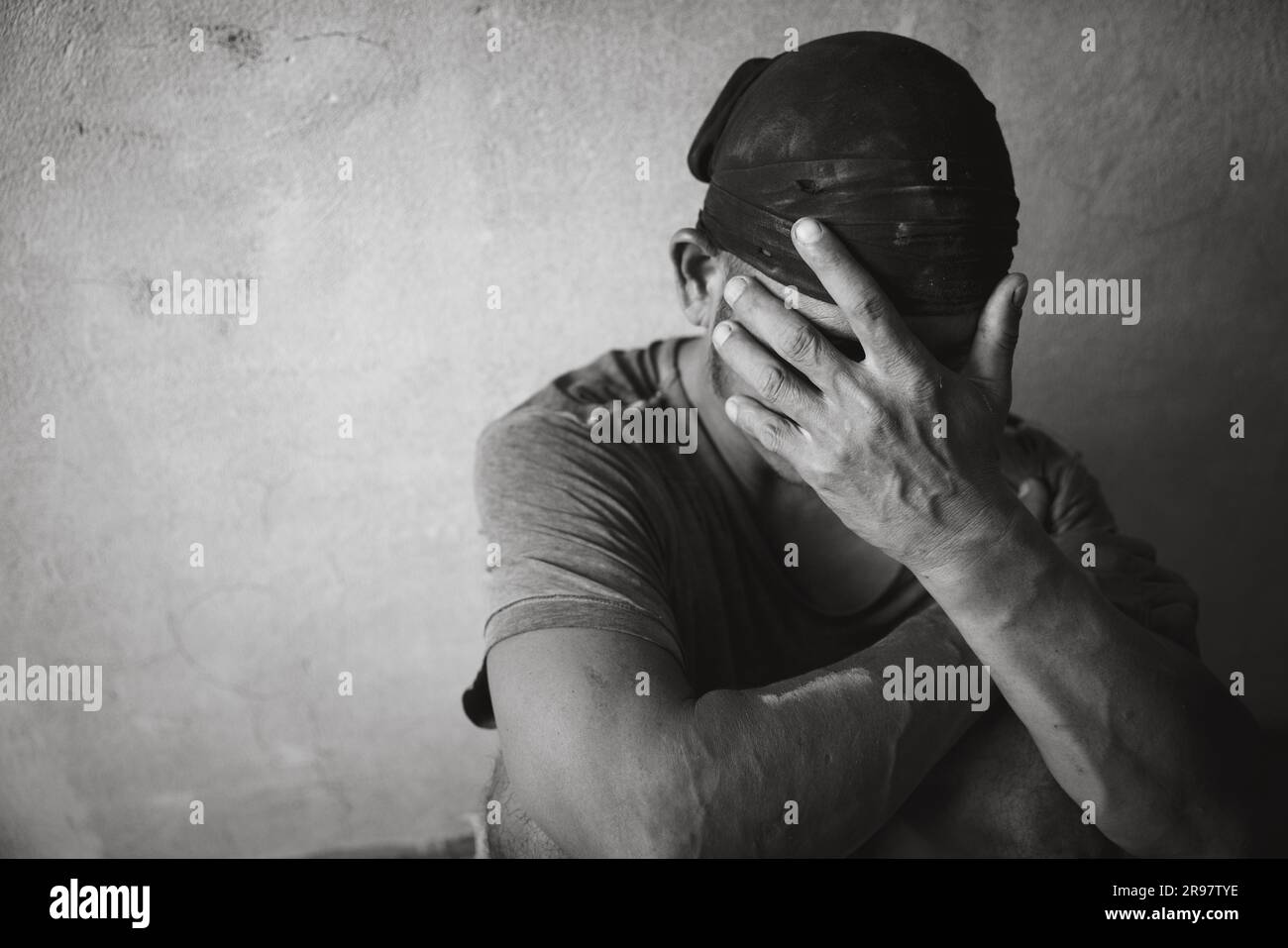 A drug addicted homeless man sitting alone and depressed in an ...