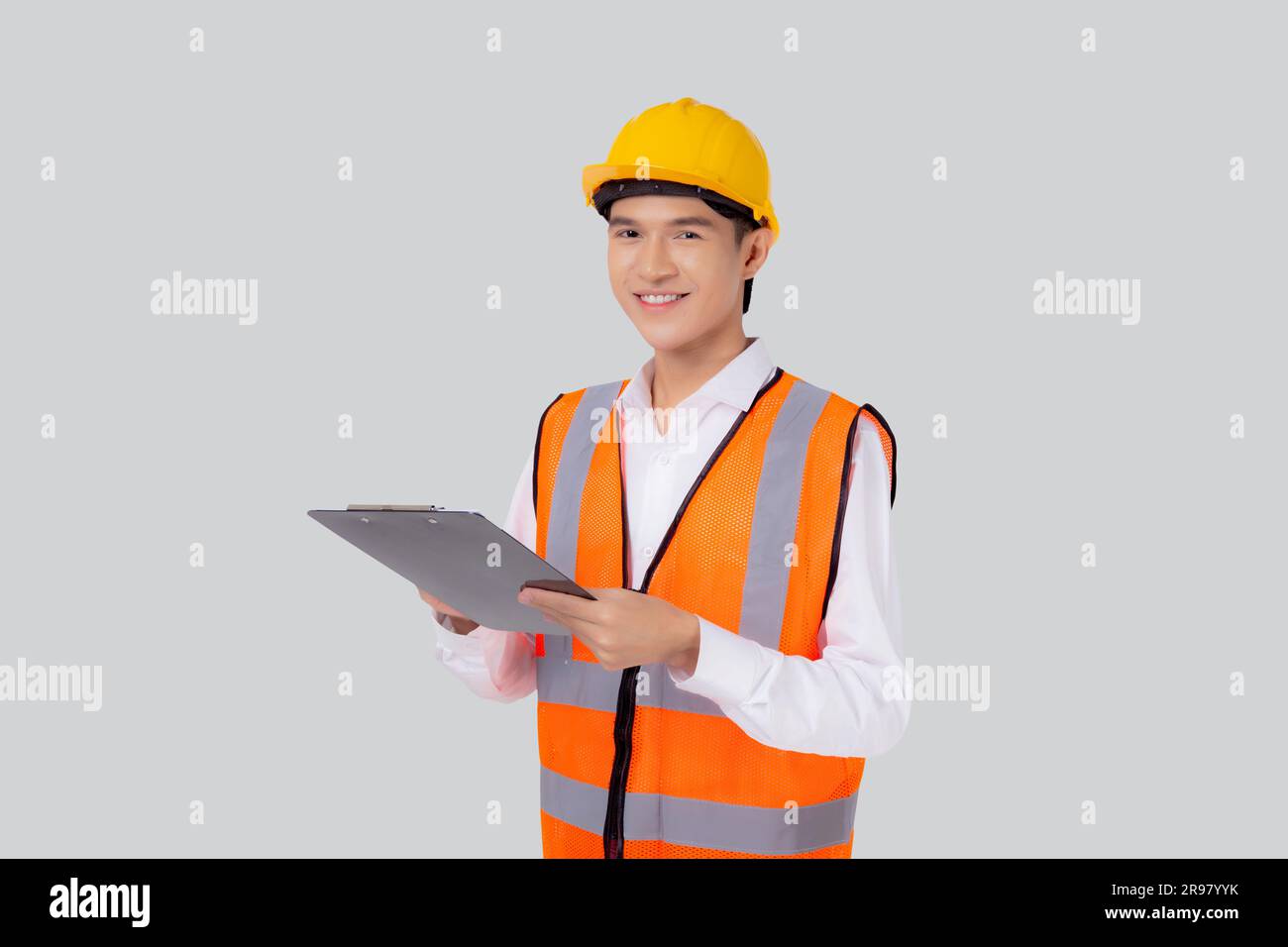 Portrait young asian engineer man wearing helmet looking document or ...
