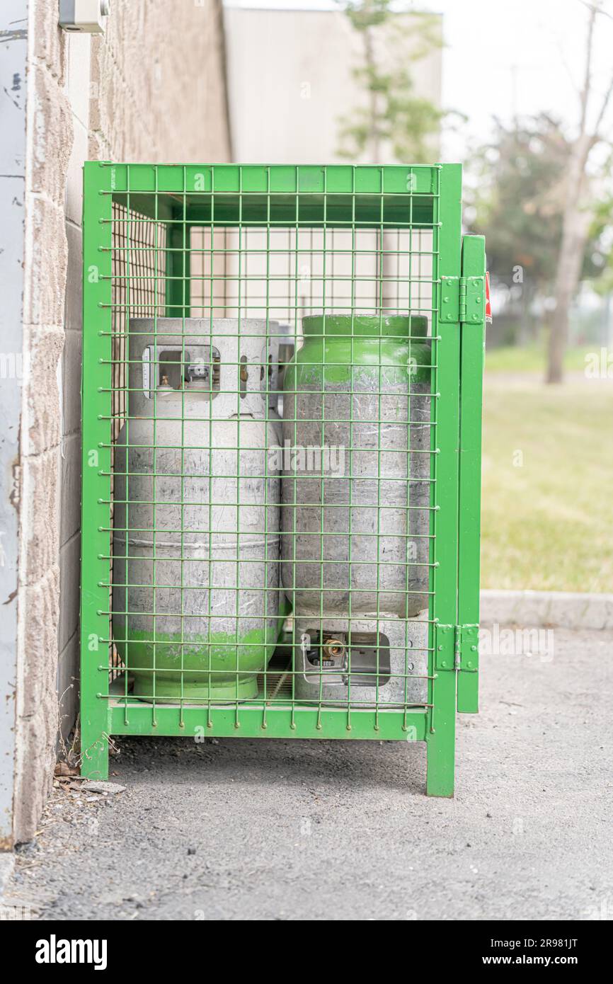 Gas cylinders in a cage for storage safekeeping Stock Photo - Alamy