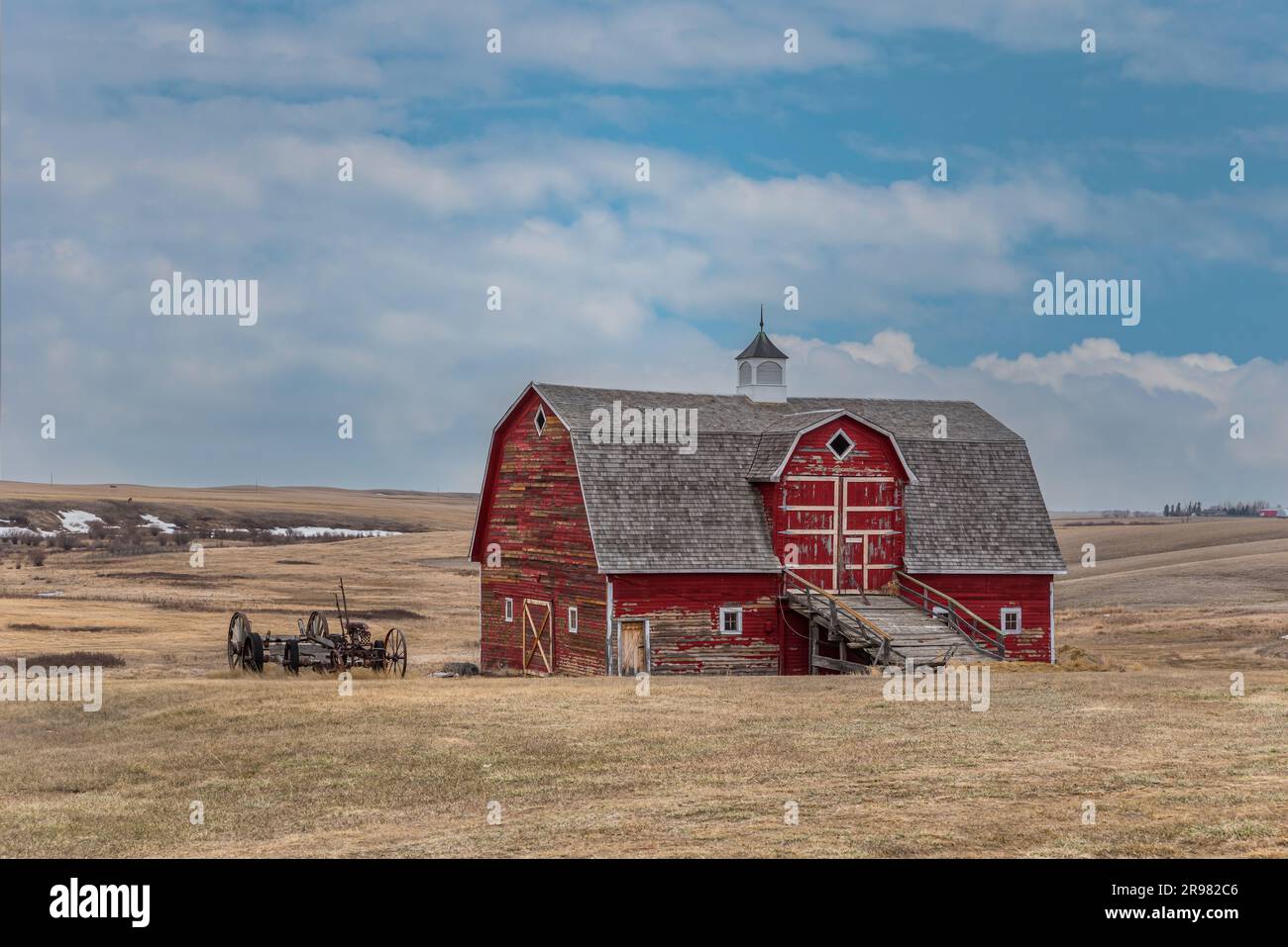 An abandoned red barn with a wagon ramp on the prairies in Saskatchewan ...