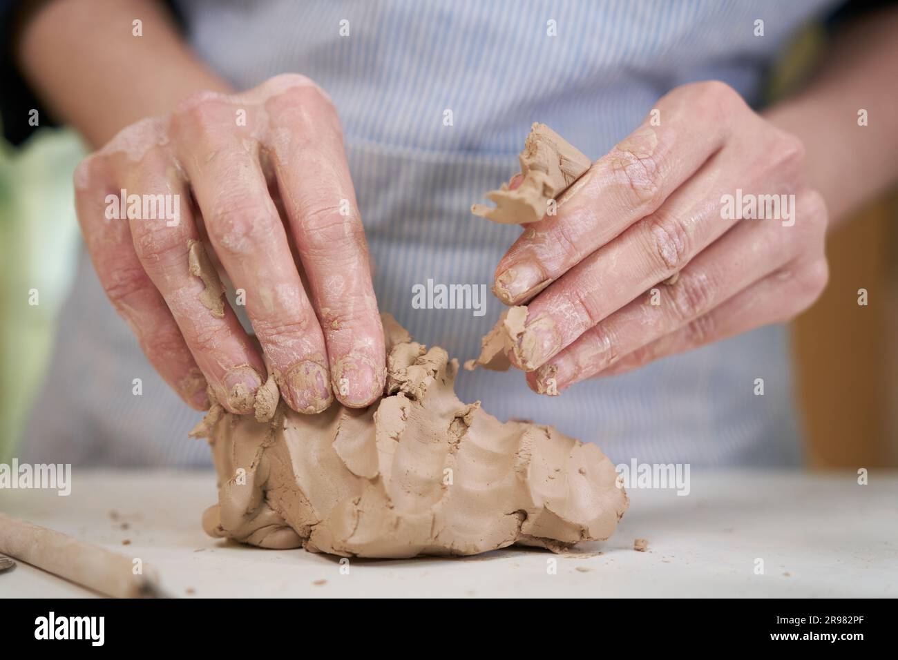 Closeup hands of ceramic artist wedging clay in art studio Stock Photo ...