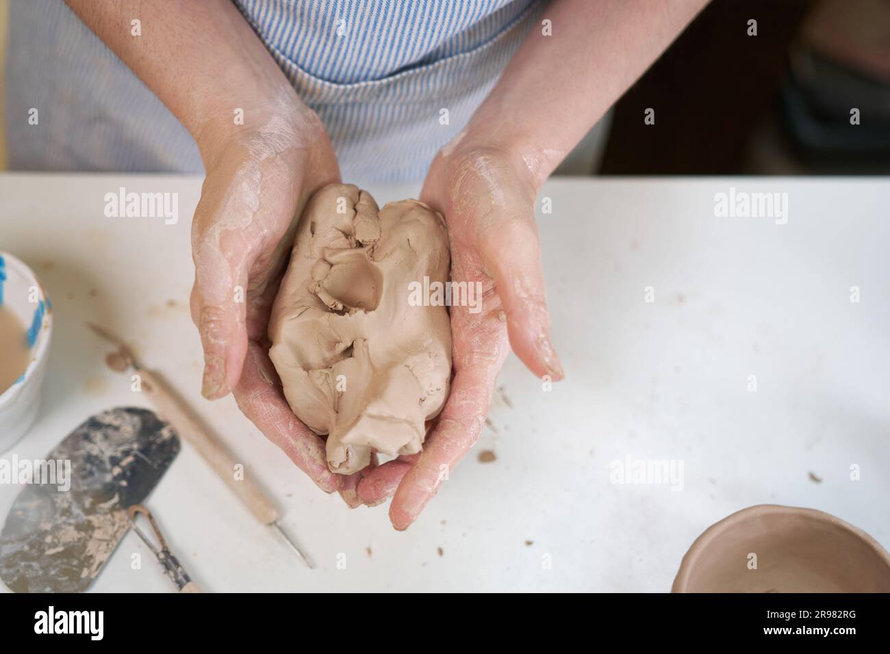 Closeup hands of ceramic artist wedging clay in art studio Stock Photo ...