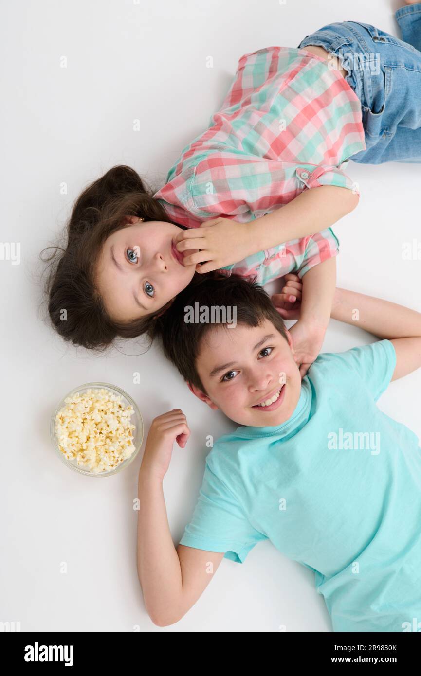 Top view happy kids smiling looking at camera, lying on their backs on ...