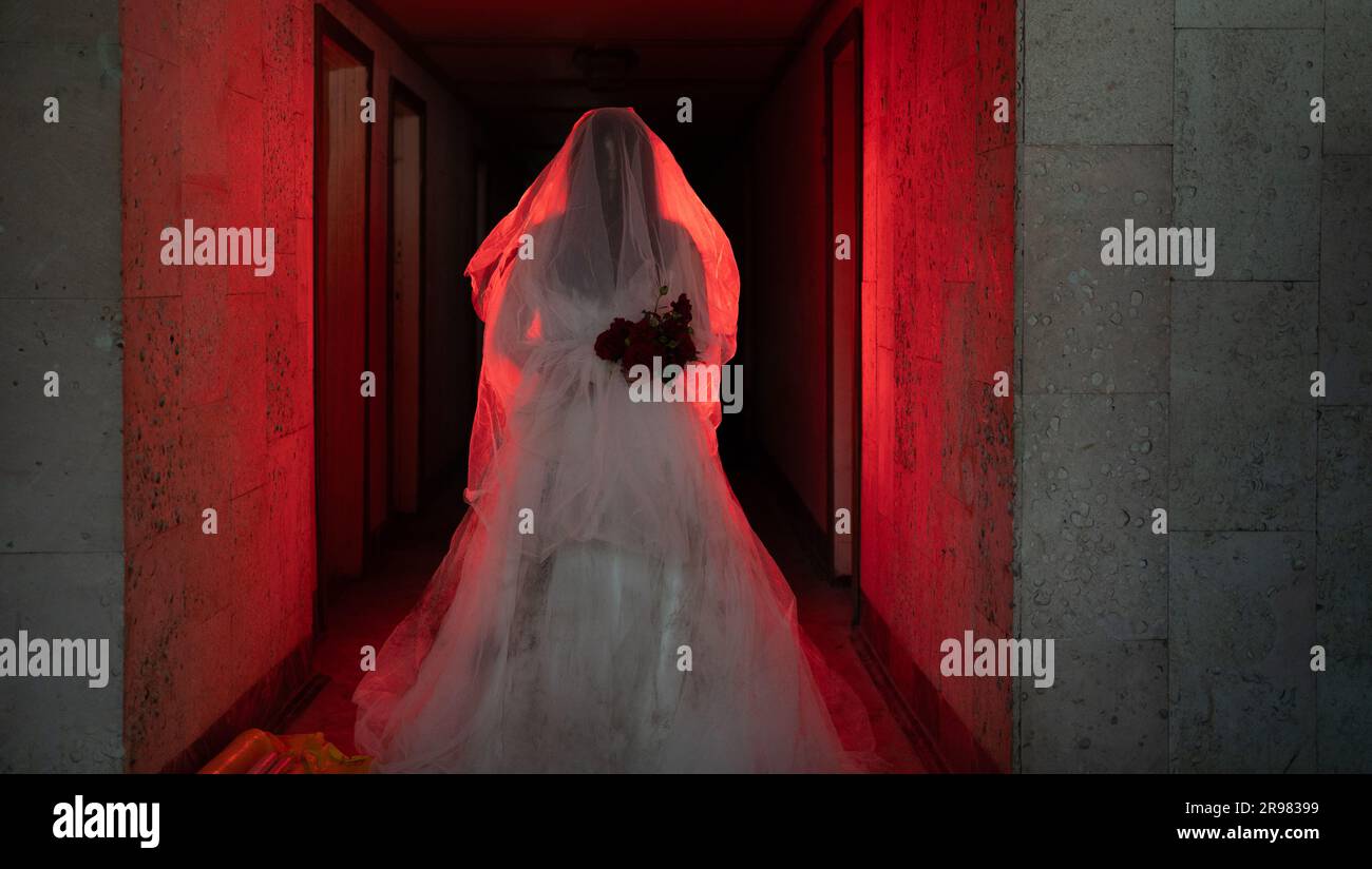 Ghostly figure of woman in wedding dress walking along a creepy hotel ...