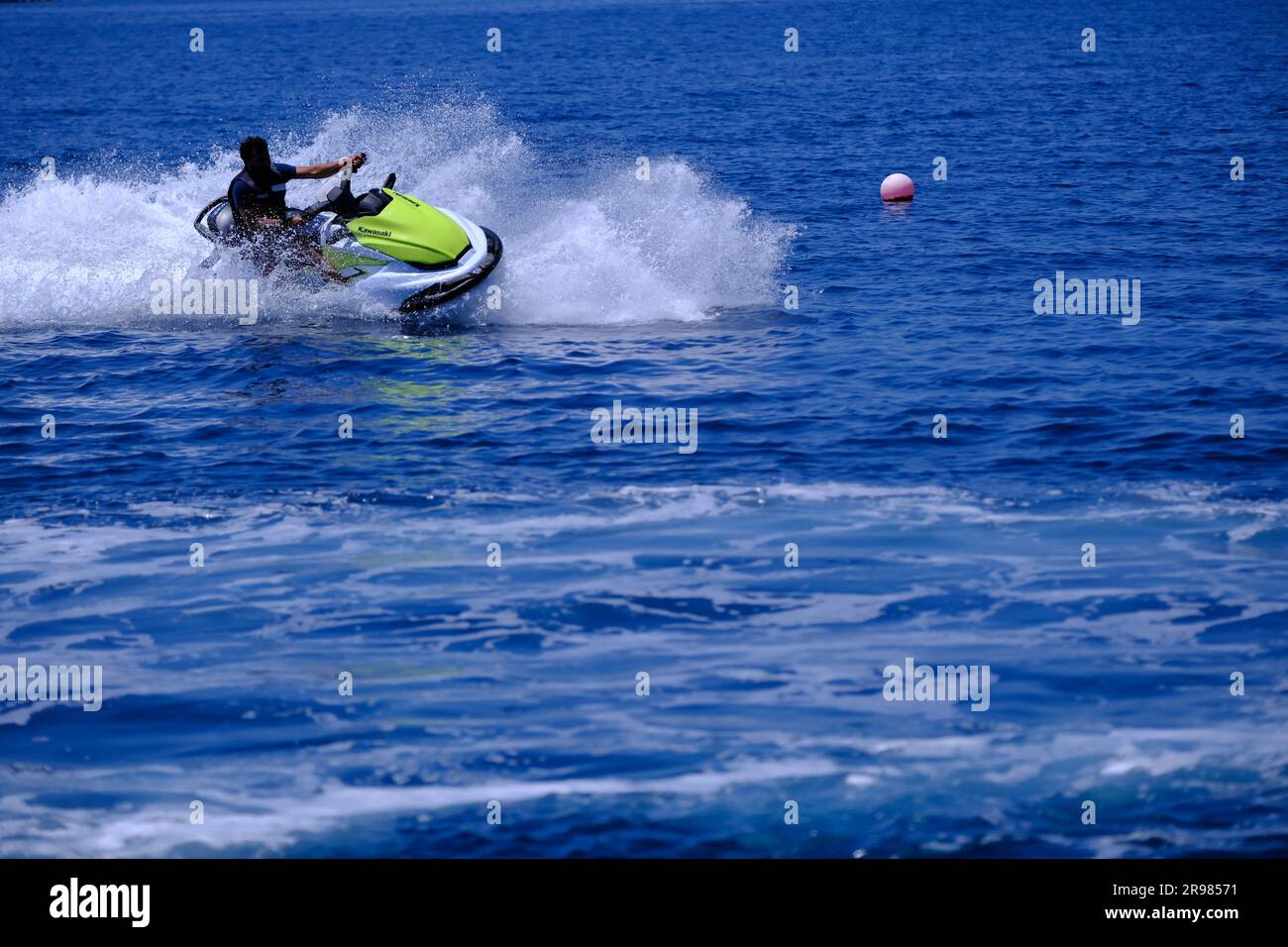 Young man with beard riding jet-ski in a sunny summer day Stock Photo ...