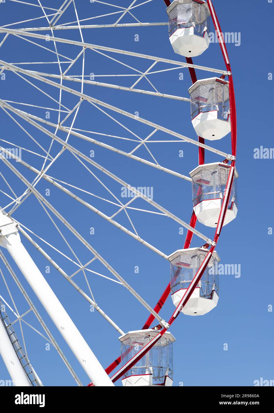 A side on photograph of a red and white colored Ferris wheel located in ...