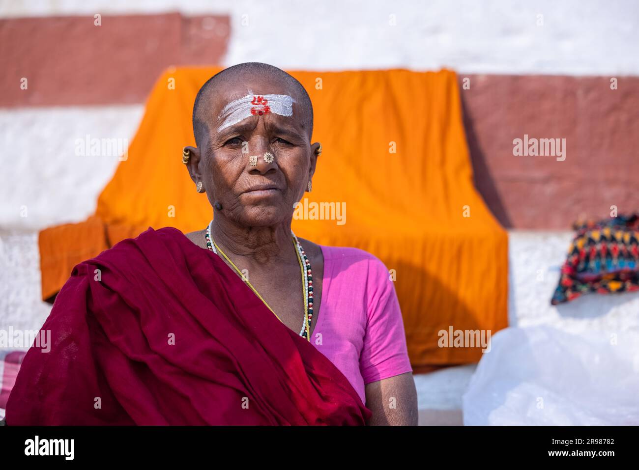 Portrait on an old south indian woman with shaved head sitting on ...