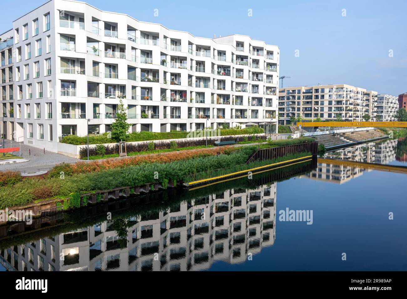 Modern apartment buildings with a reflection in a small canal seen in ...