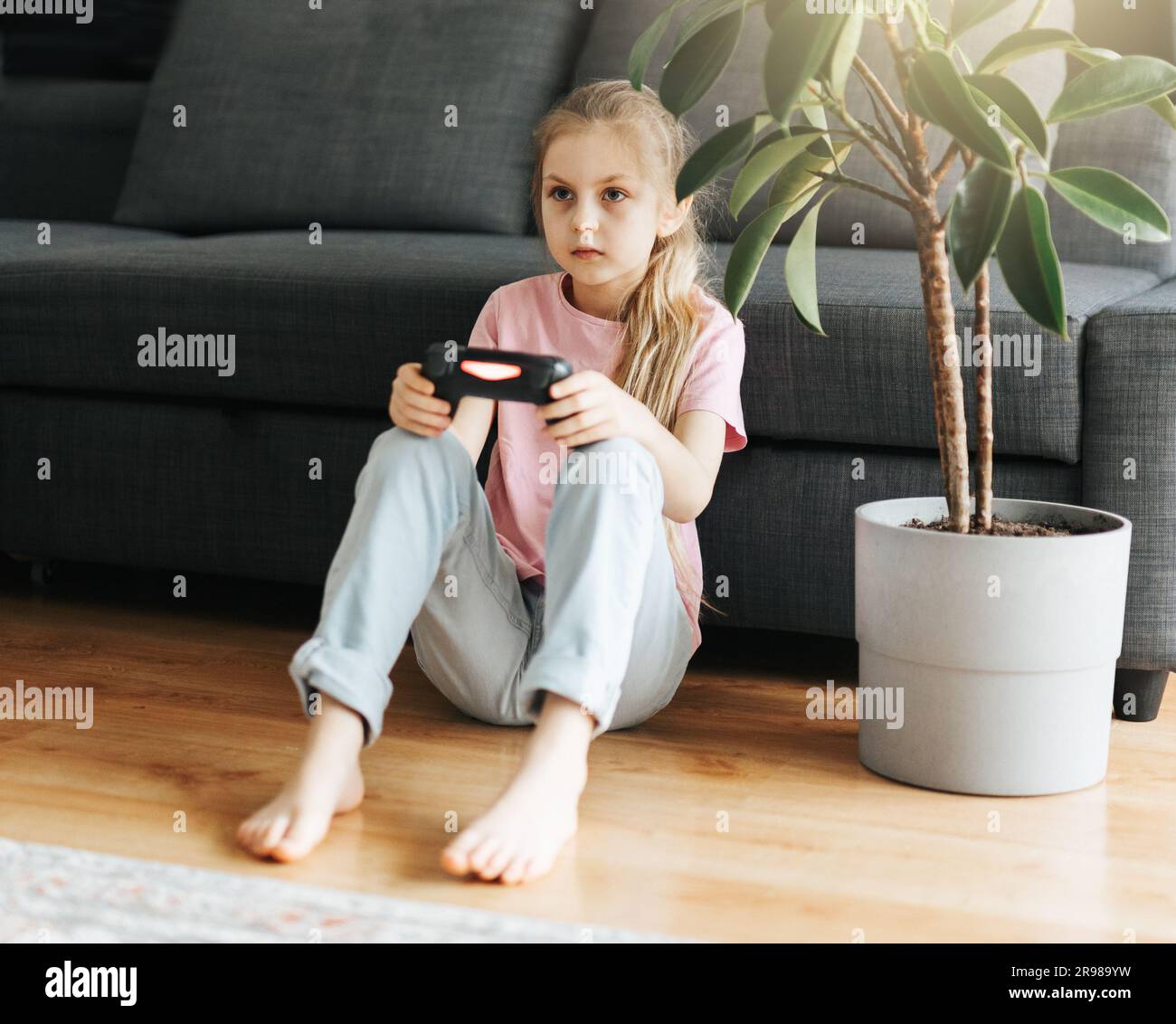 A little girl is playing with a game console at home Stock Photo - Alamy