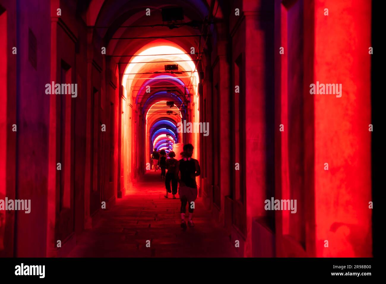 Bologna,Italy- June 23, 2023:People stroll at night under the arcades ...
