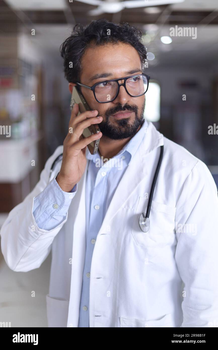 Portrait of smart male doctor talking over mobile phone call. Happy ...