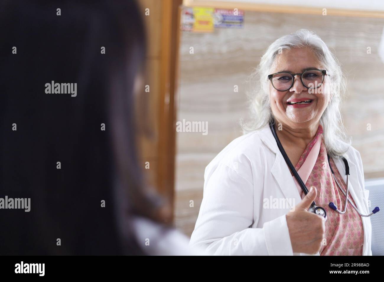 Indian doctor in discussion with assistant. Doctors laugh and talk in ...