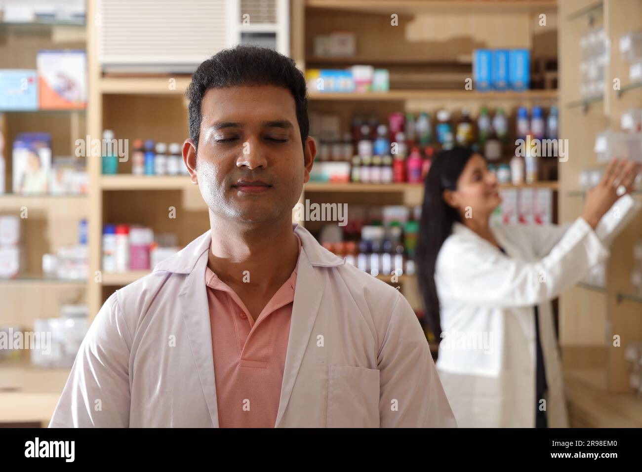 Pharmacist chemist Indian man standing in pharmacy - drugstore. Close ...