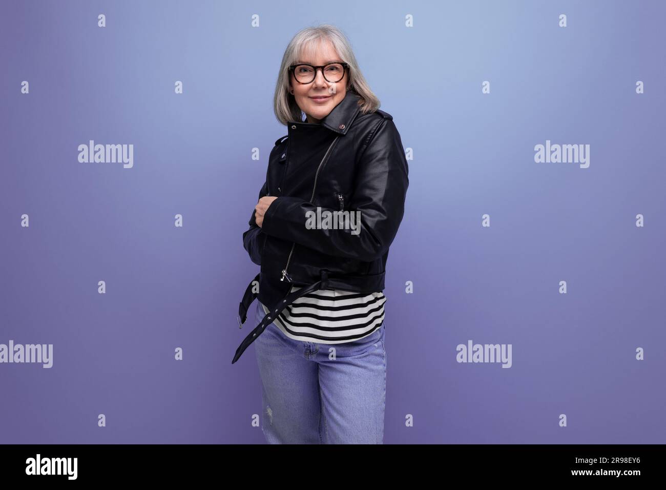 mature old woman in a stylish rocker jacket on a bright background ...