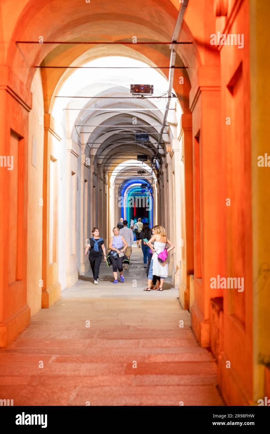Bologna,Italy- June 23, 2023:People stroll at night under the arcades ...