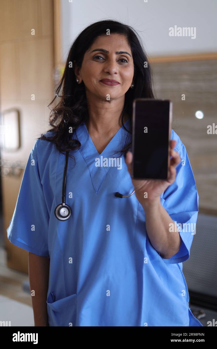 Portrait Of Smart Female Nurse Showcasing Mobile Phone Screen Happy