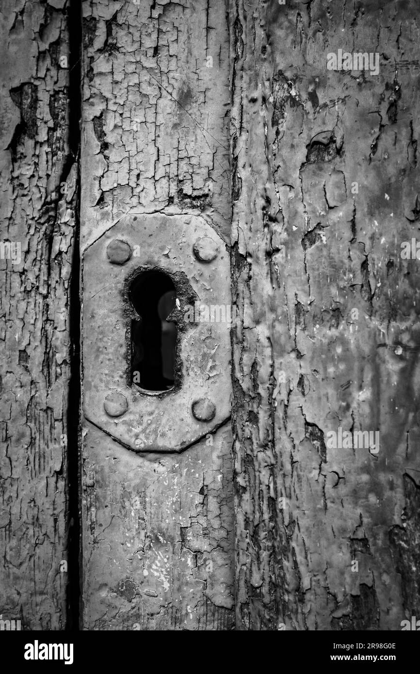 Closeup view of the keyhole in an ancient blue wooden door with rough ...