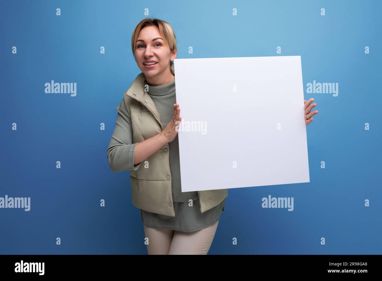 blond young woman demonstrates a paper poster with a layout for ...