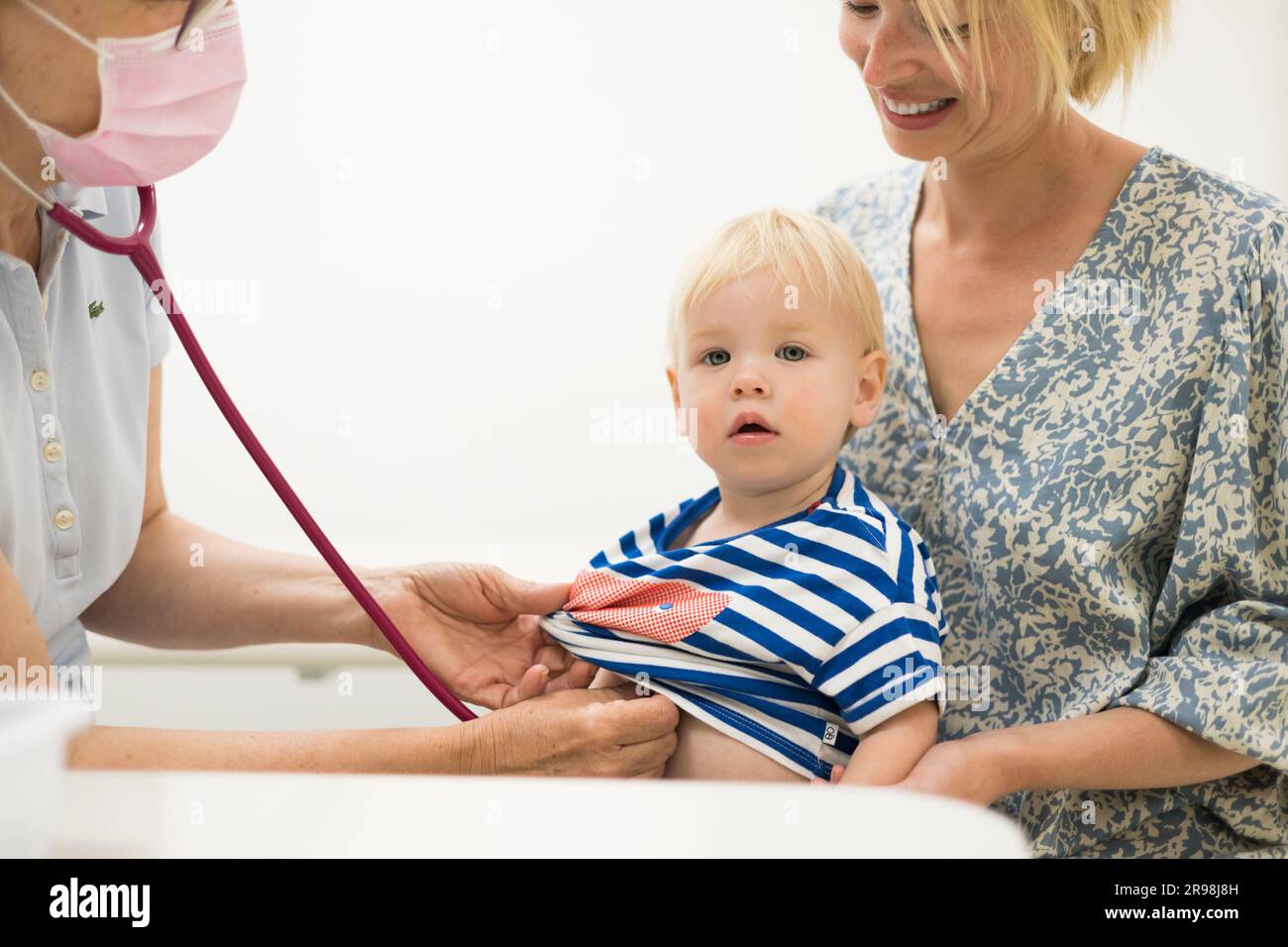 Infant baby boy child being examined by his pediatrician doctor during ...