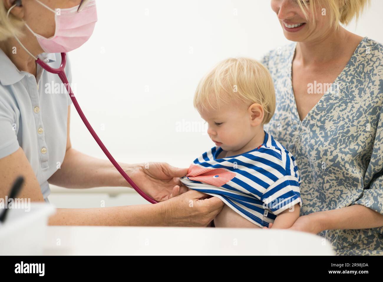 Infant baby boy child being examined by his pediatrician doctor during ...