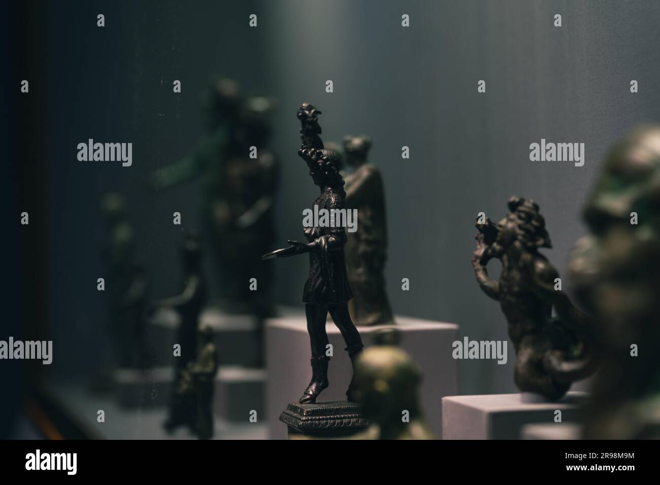 Several statues of a person featured on white pedestals are showcased ...