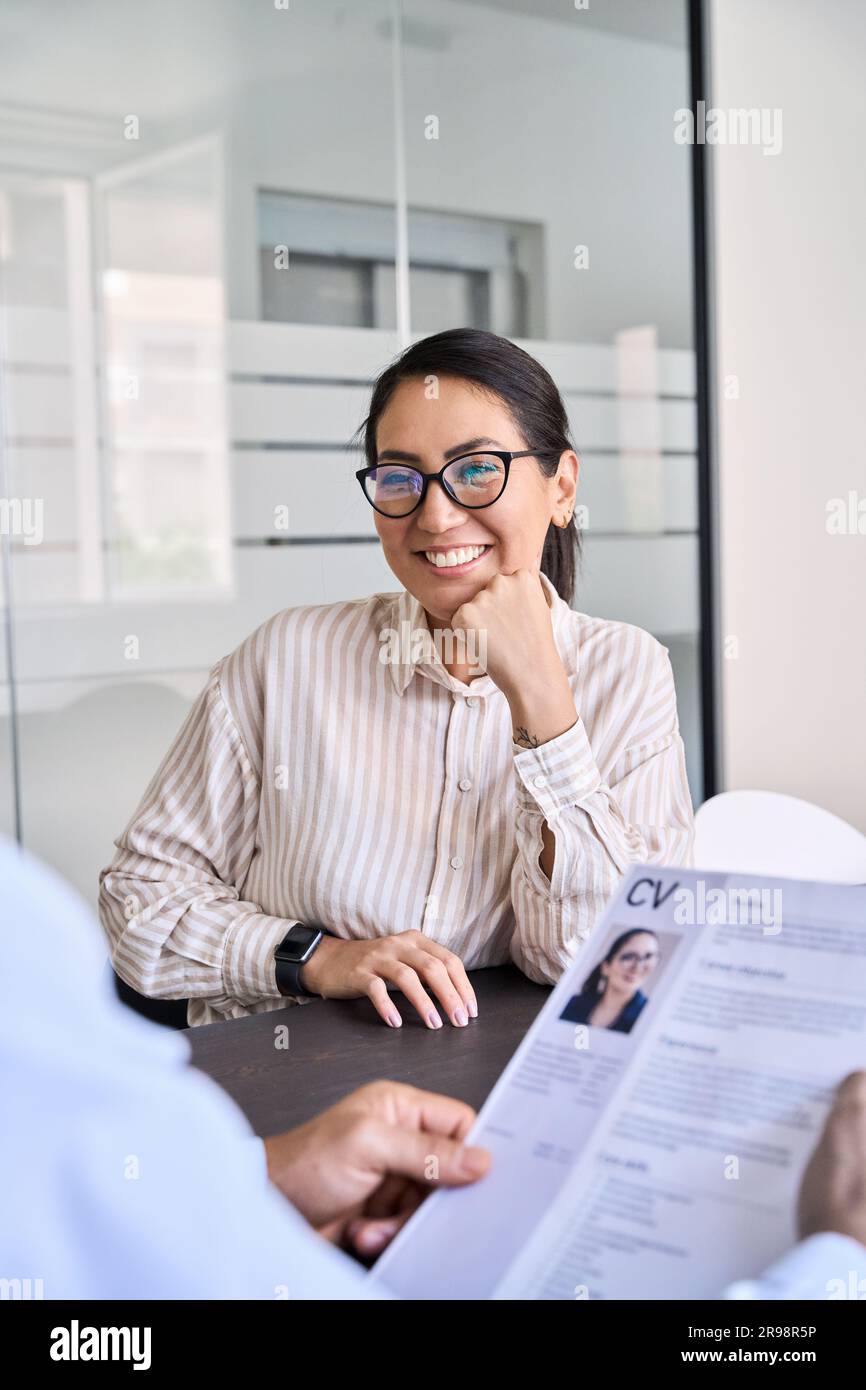 Smiling Asian woman candidate and hr manager holding cv during job ...