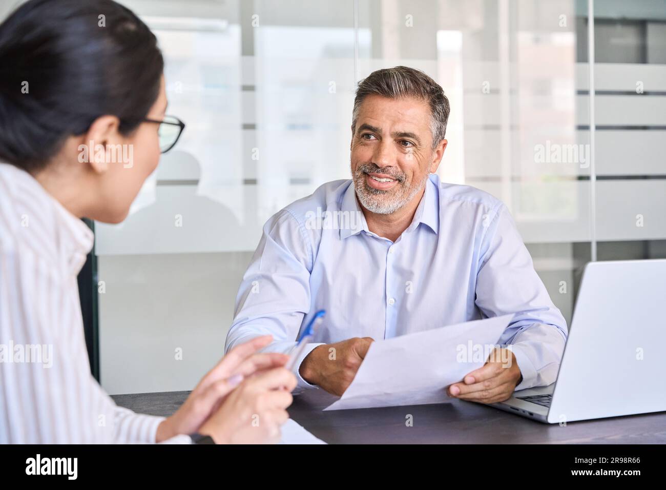 Smiling Latin male hr manager holding cv during interview in office ...
