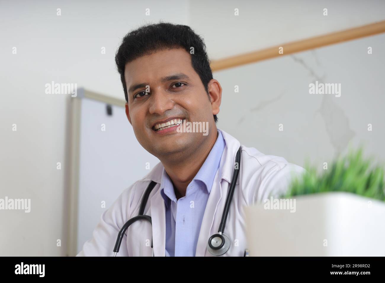 young Indian doctor sitting with patient having a detailed conversation ...