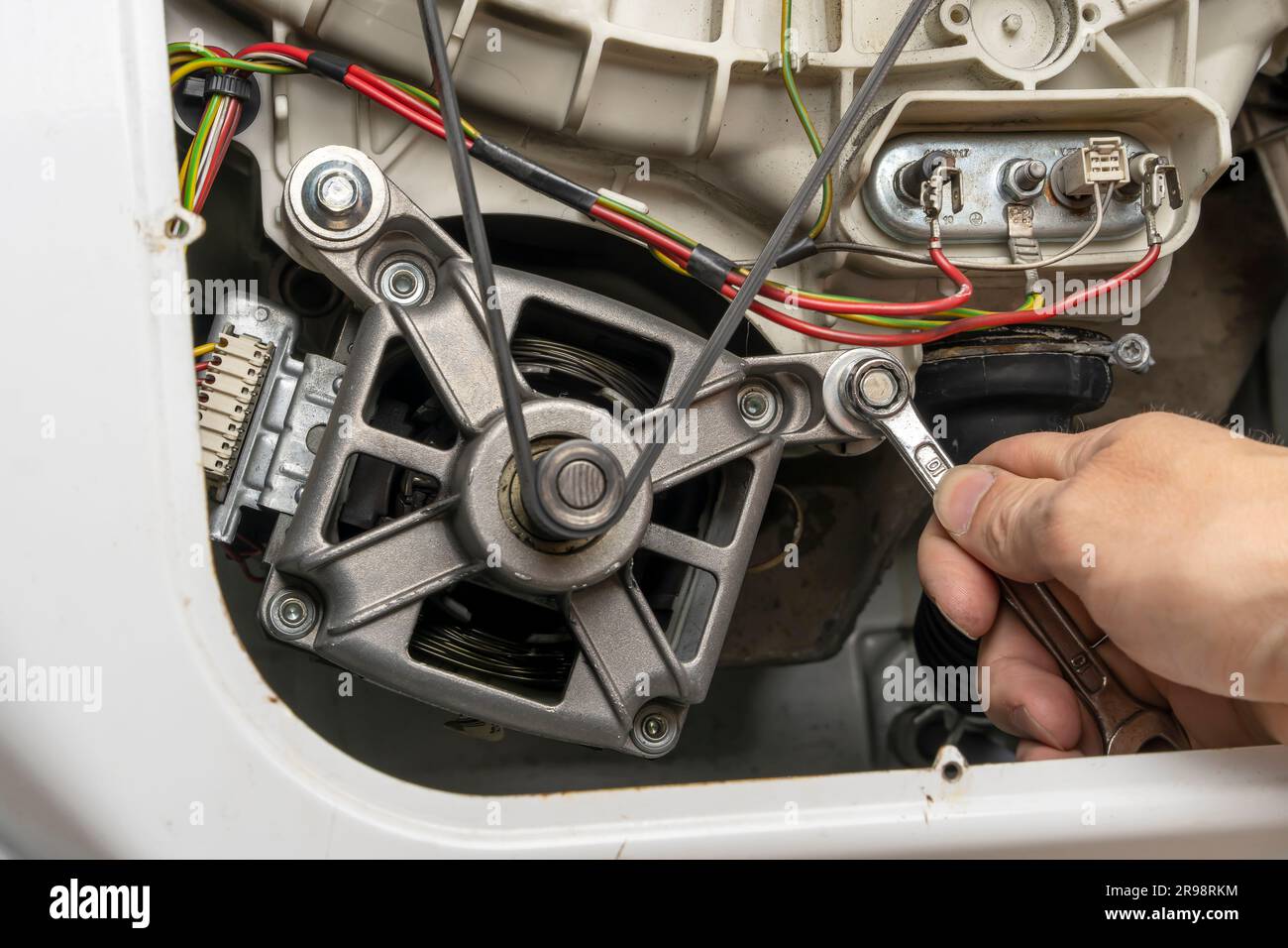 The repairman repairs the washing machine. the hand of the serviceman ...