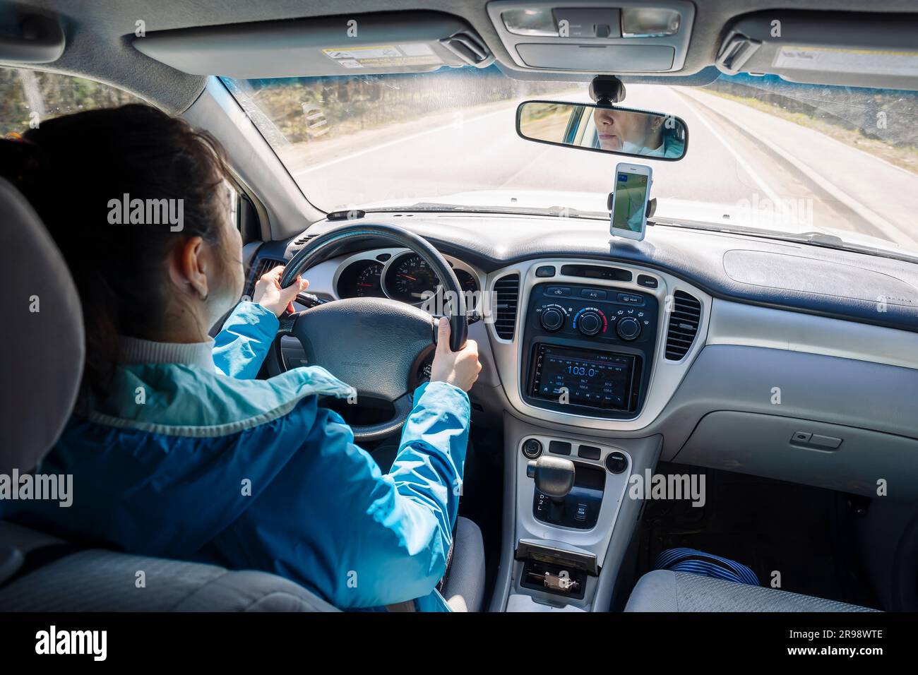 caucasian middle-aged woman driving a car on the highway. A view from ...