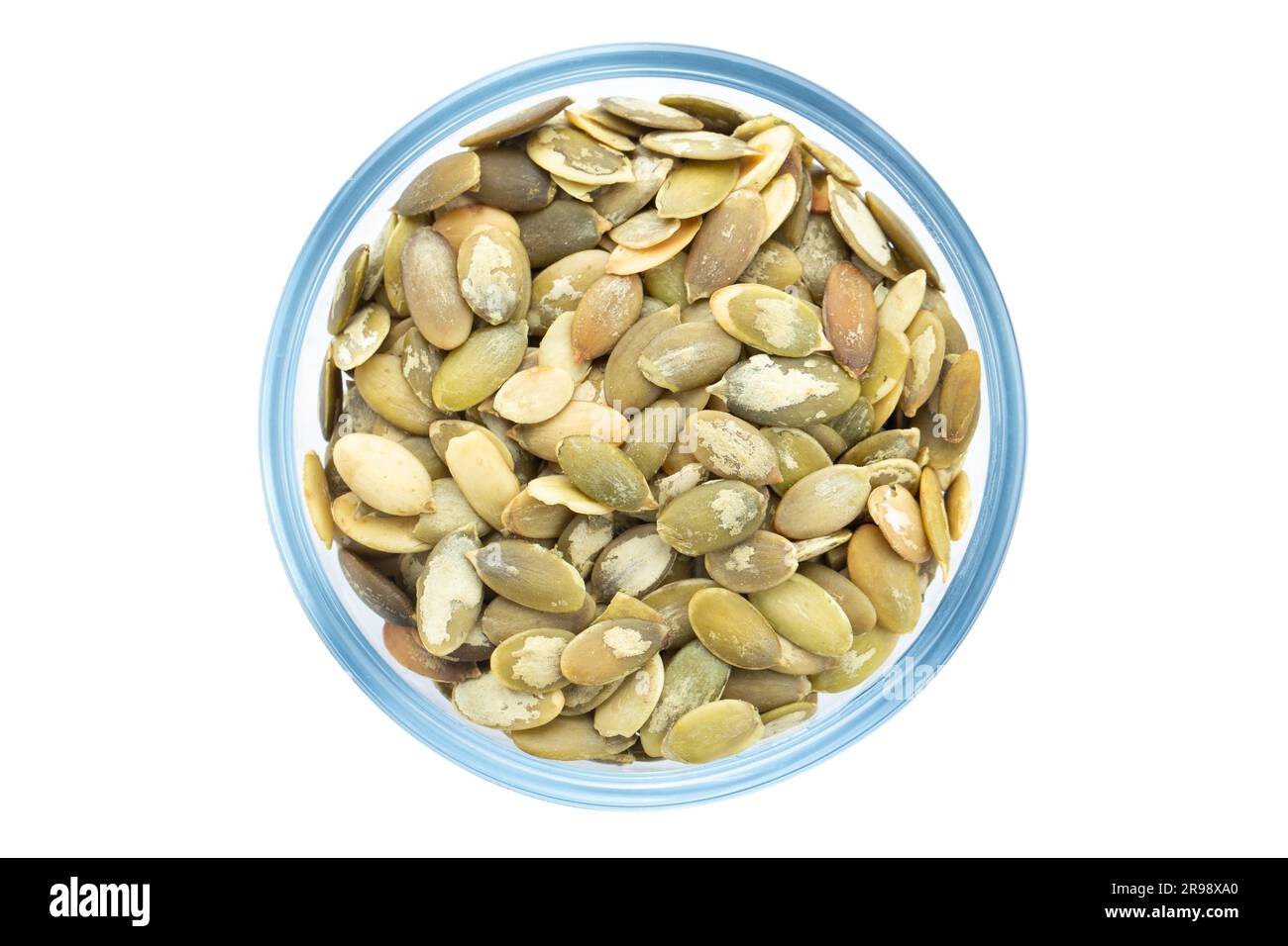 Peeled pumpkin seeds in a bowl, top view. Isolated on white background ...