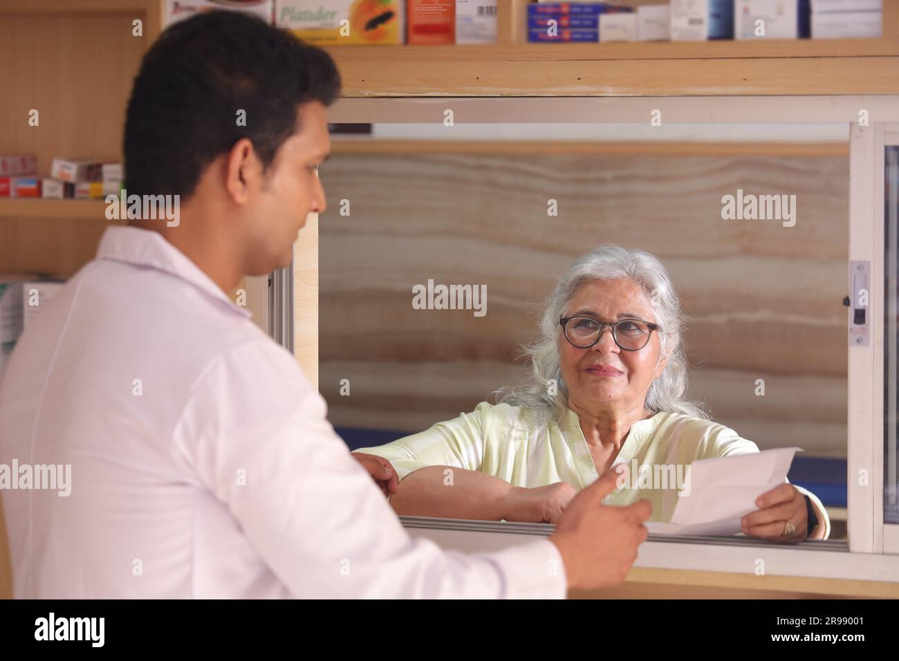 Pharmacist chemist Indian man standing in pharmacy - drugstore. Close ...