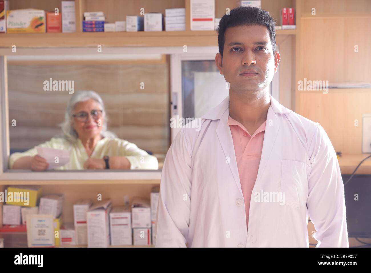 Pharmacist chemist Indian man standing in pharmacy - drugstore. Close ...
