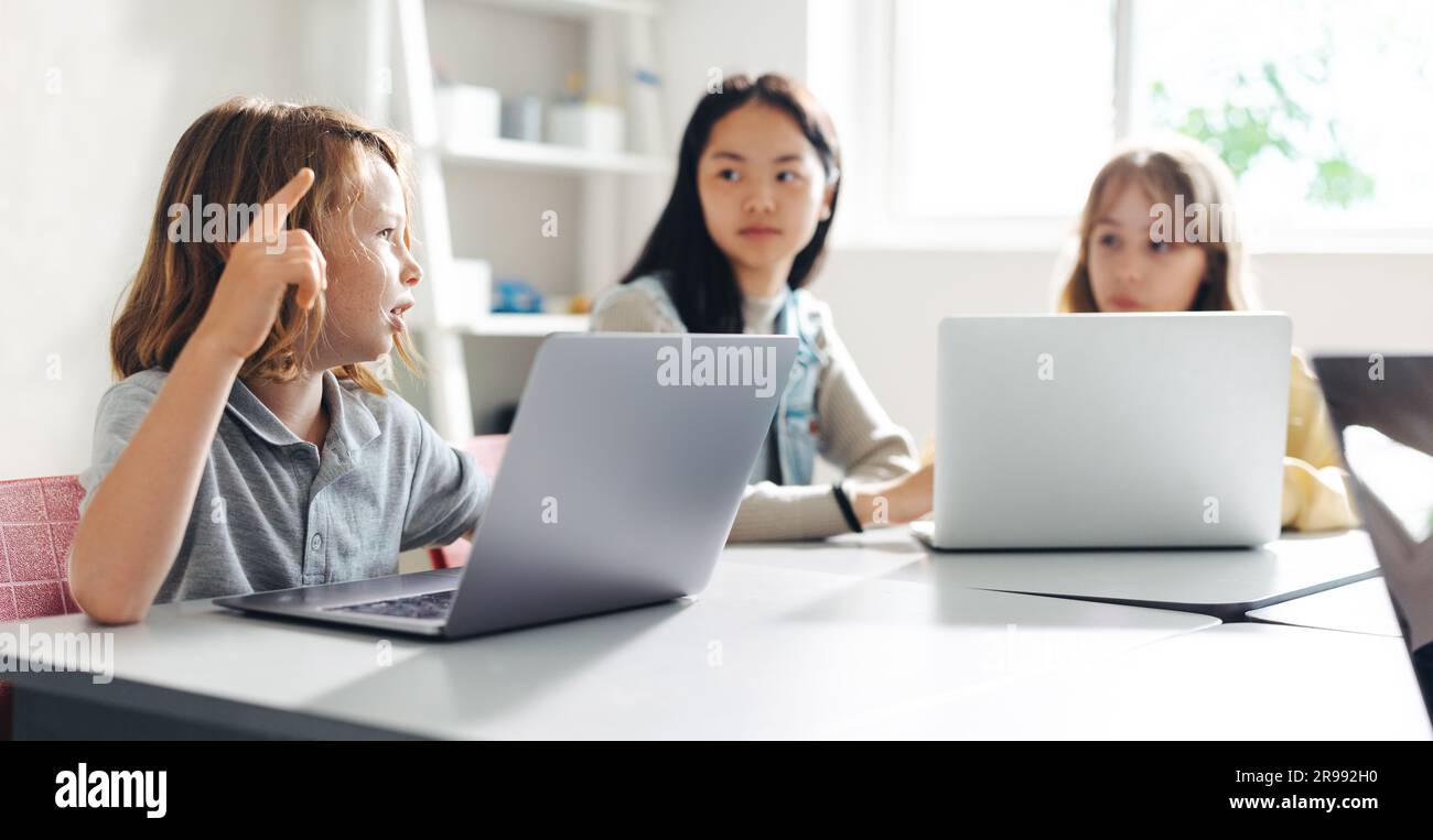 Children in a computer-based learning classroom collaborate and assist ...
