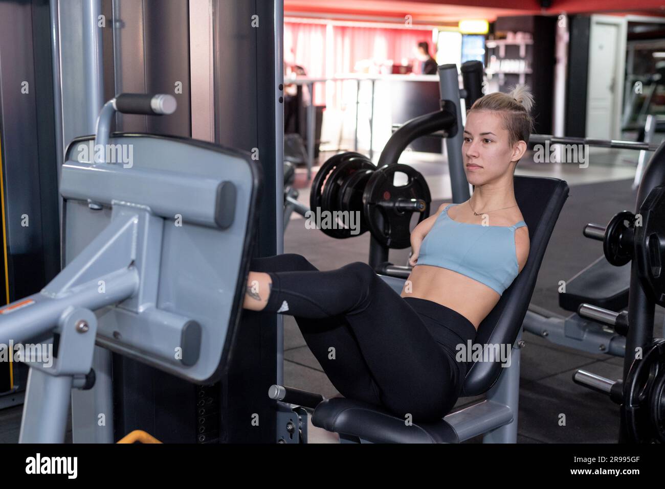 Woman without arms training in a gym doing leg press Stock Photo - Alamy