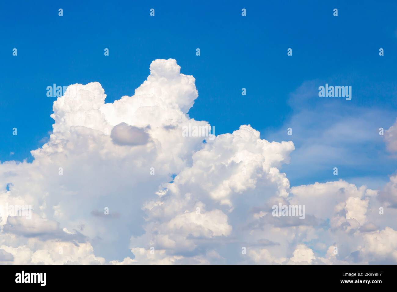 Summer sunlight illuminating a large thundercloud, and smaller ...