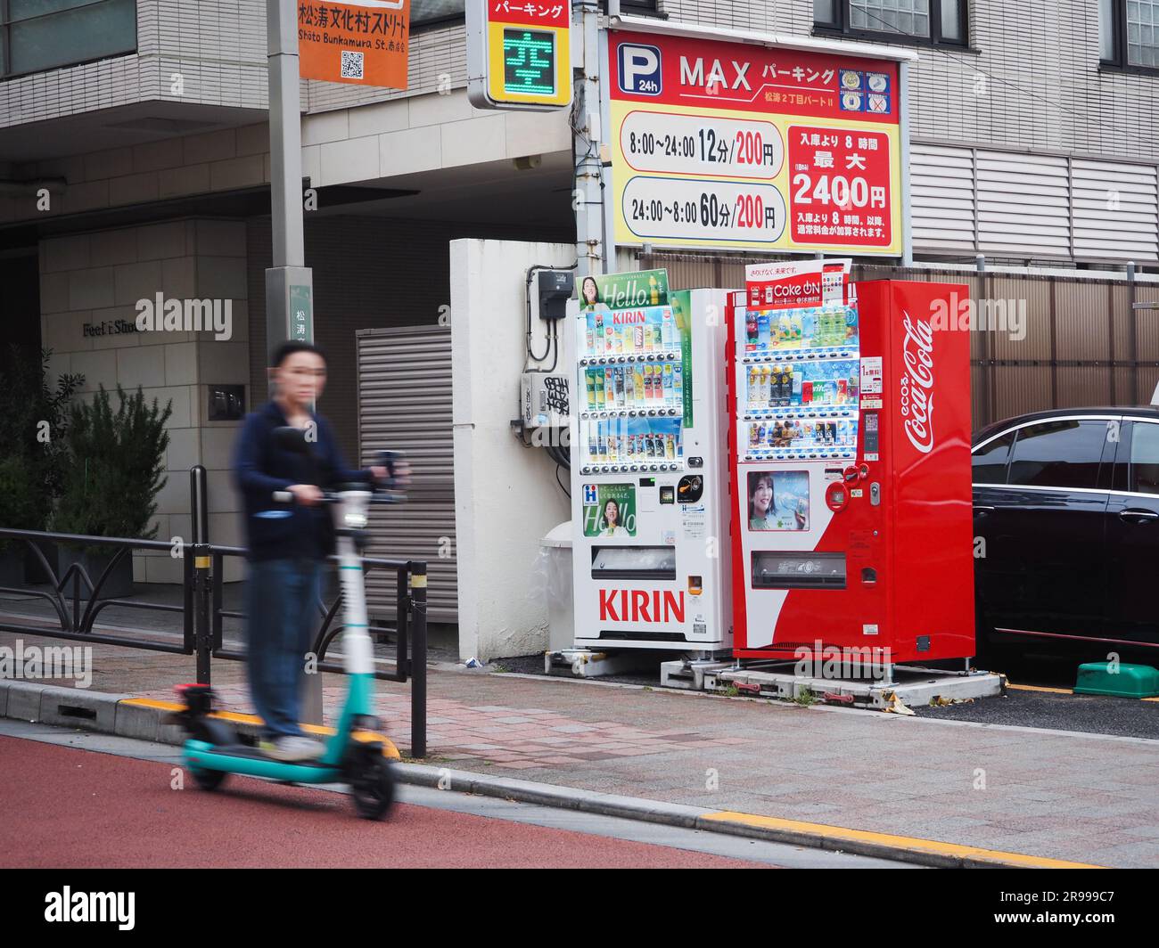 TOKYO, JAPAN - June 9, 2023: A rider on a rented e-scooter goes down a ...