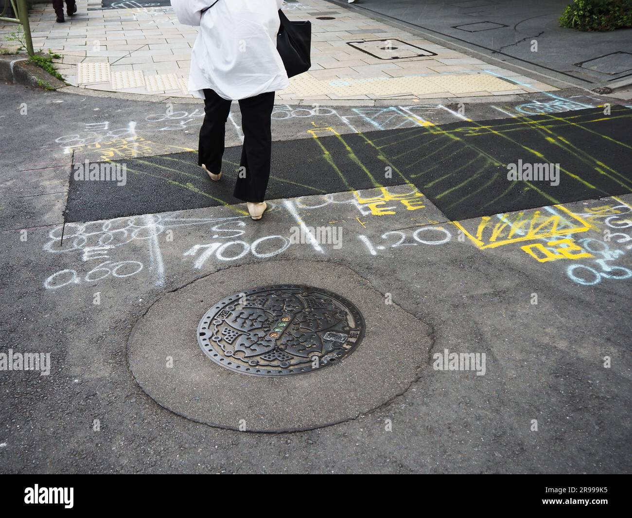 TOKYO, JAPAN - May 1, 2022: Street with water company manhole cover and ...
