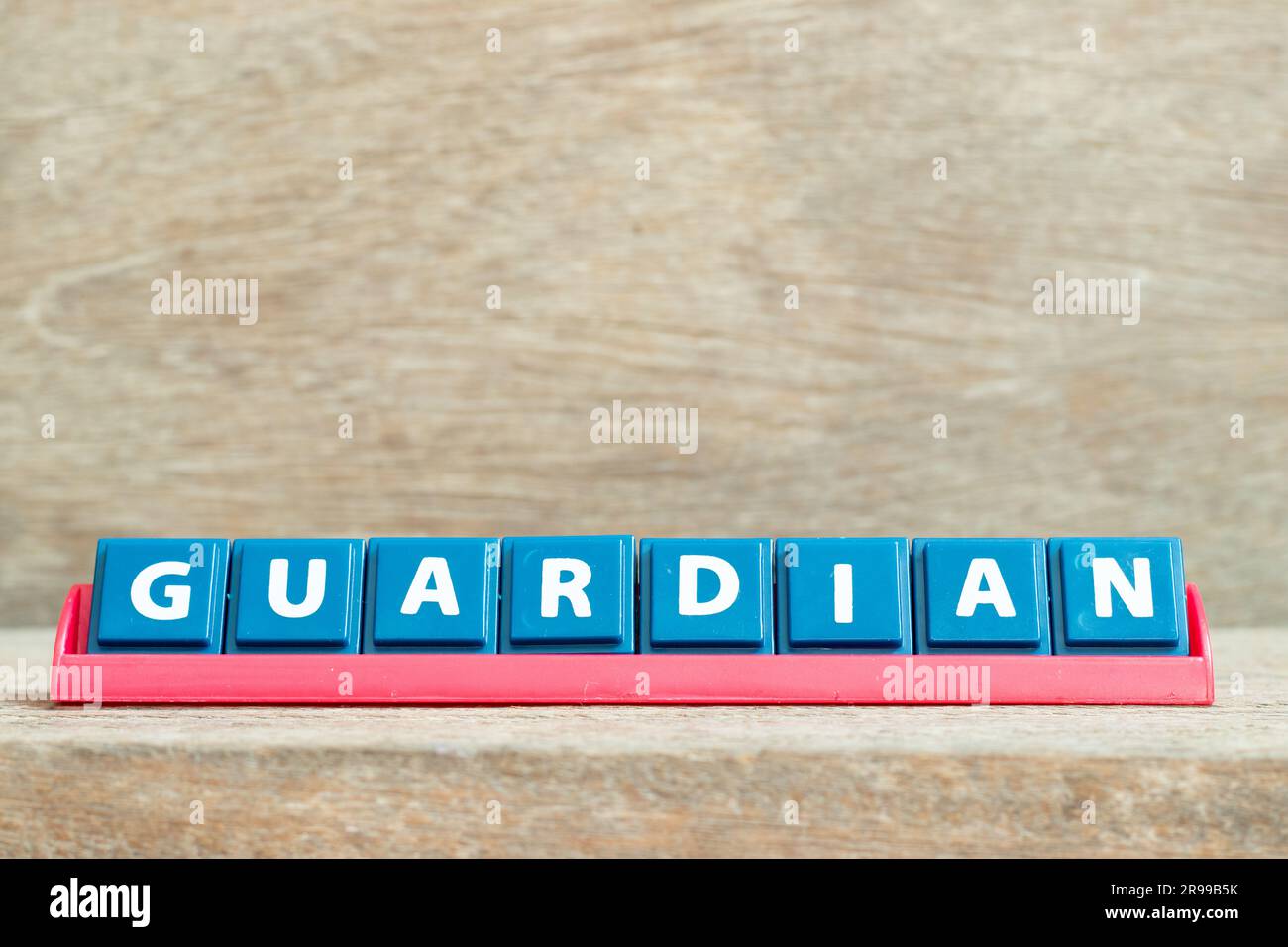Tile alphabet letter with word guardian in red color rack on wood ...