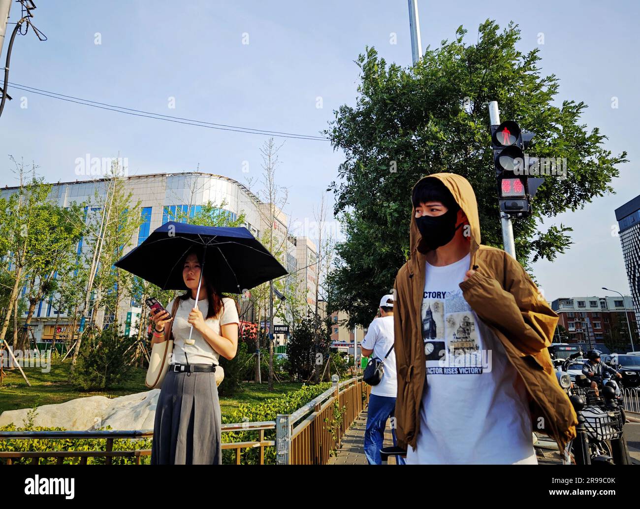 BEIJING, CHINA - JUNE 25, 2023 - People walk with sun protection ...